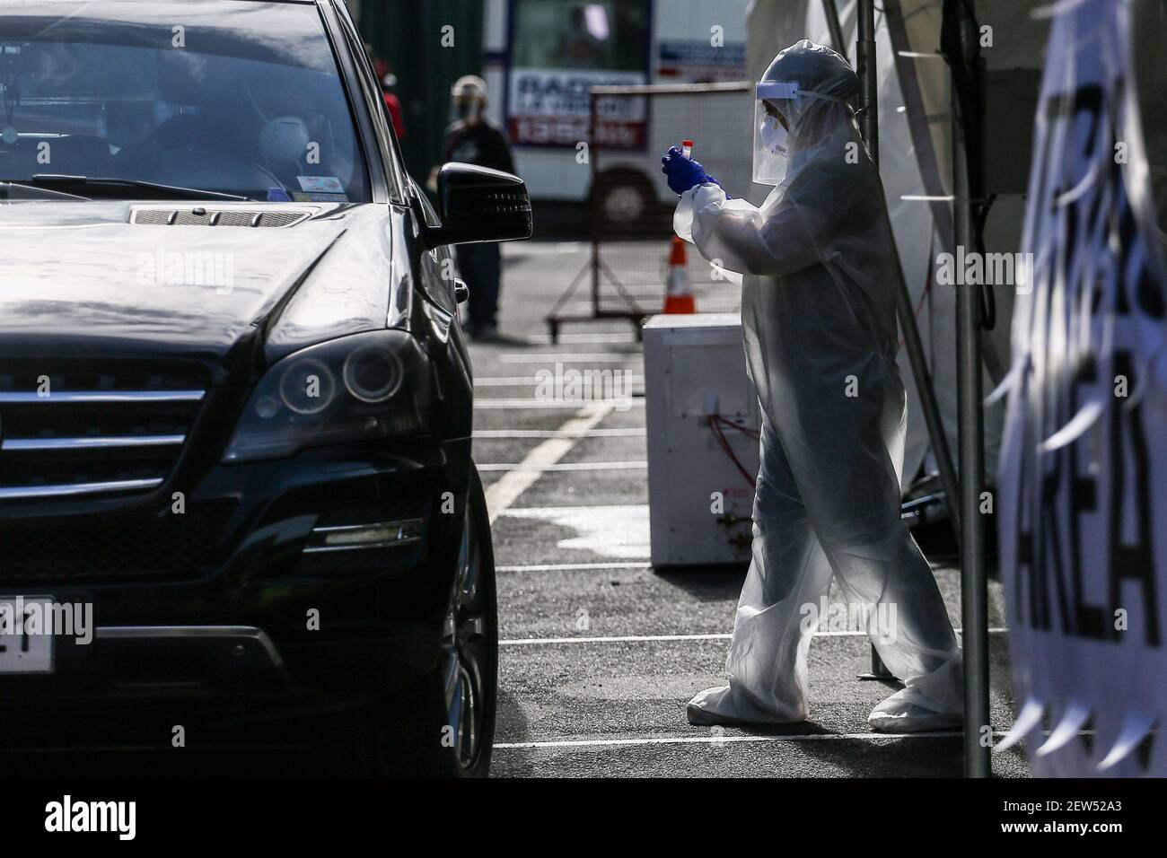 A medical worker holds Universal Transport Medium (UTM) tubes at a ...