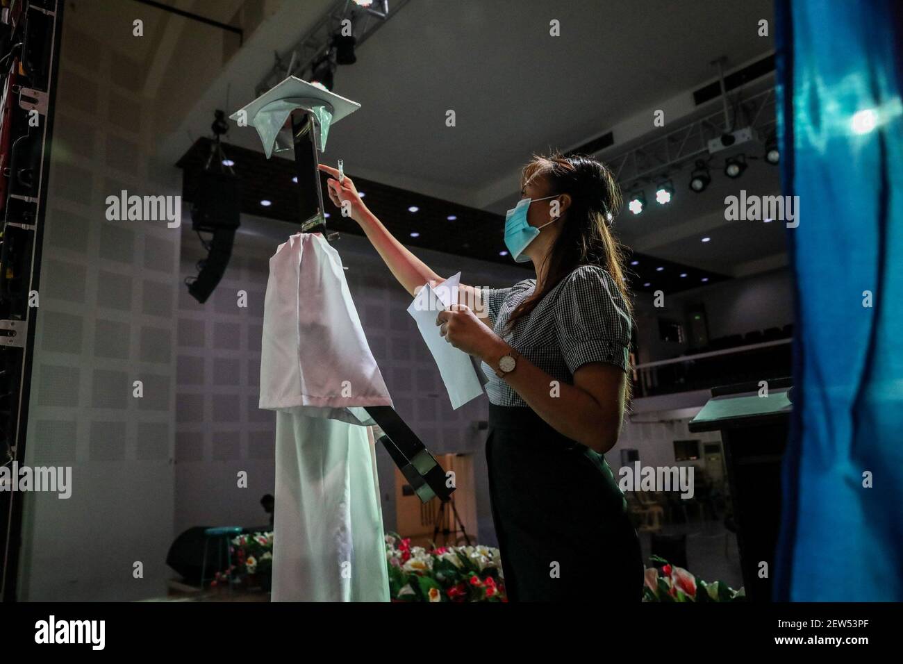 A teacher sets up a tablet attached to a robot wearing a toga during a ...