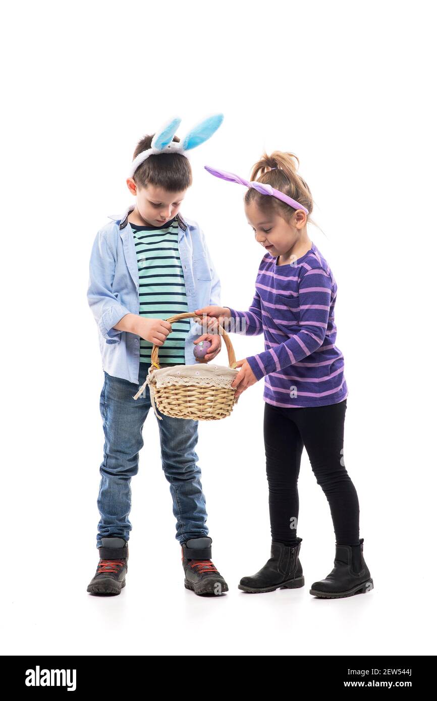 Cute little girl and boy holding basket searching for Easter eggs hunt ...