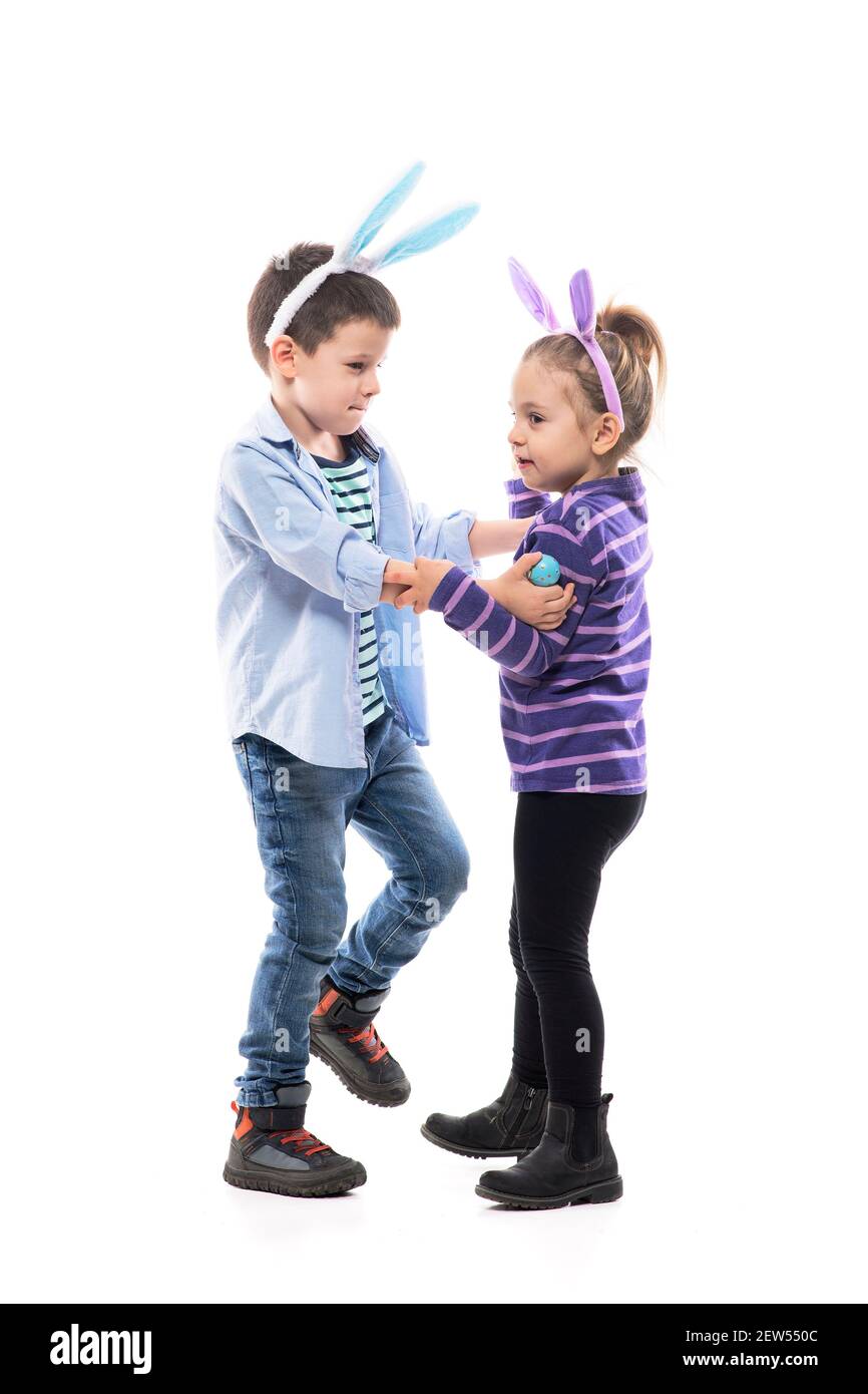Dancing young boy and girl children celebrating Easter with bunny ears ...