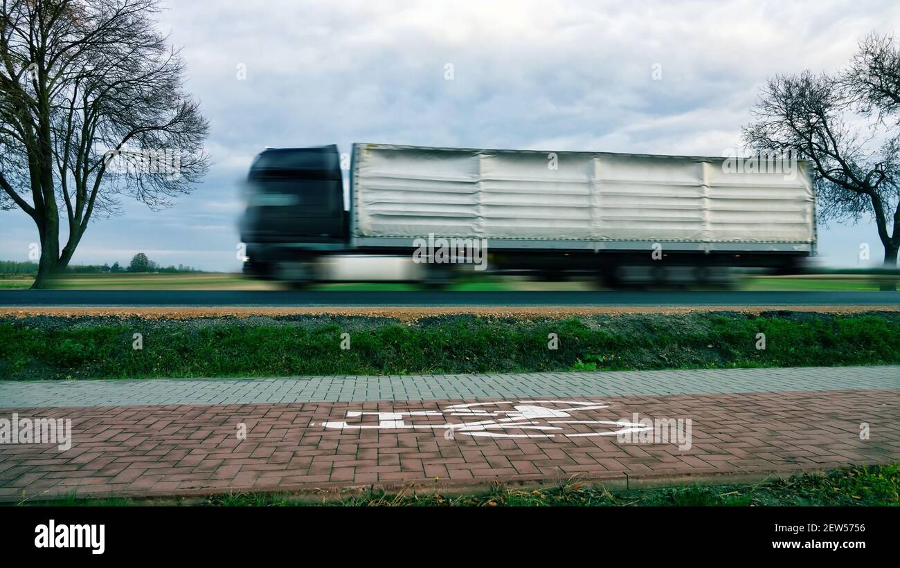 Heavy goods vehicle on highway. Car is blurred to make it impossible to ...