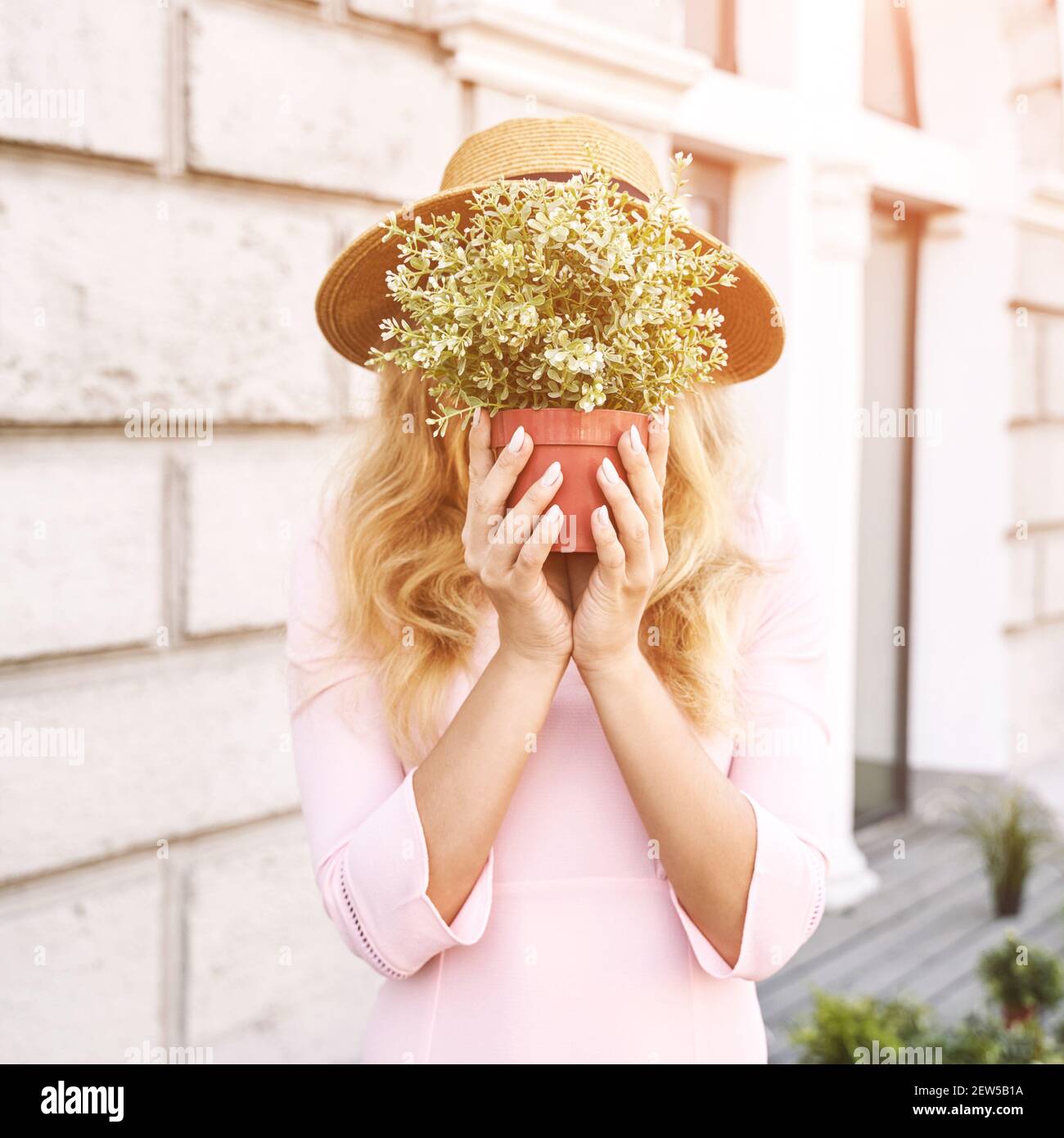 Pretty young woman hide face by green. Outdoors anonymity portrait ...