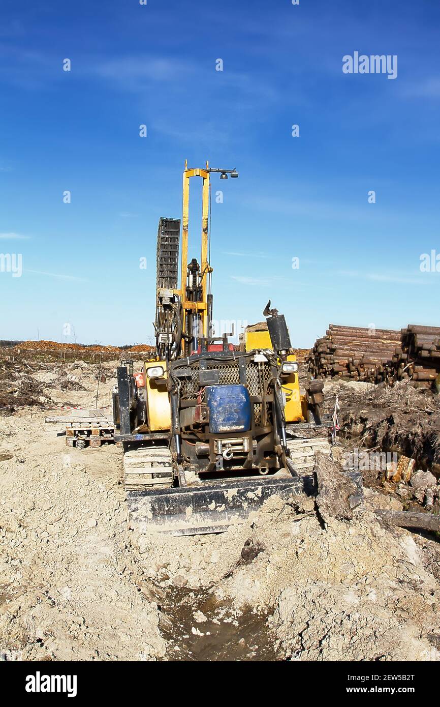 Mini-drilling rig on crawler track on site of sawn forest where large ...