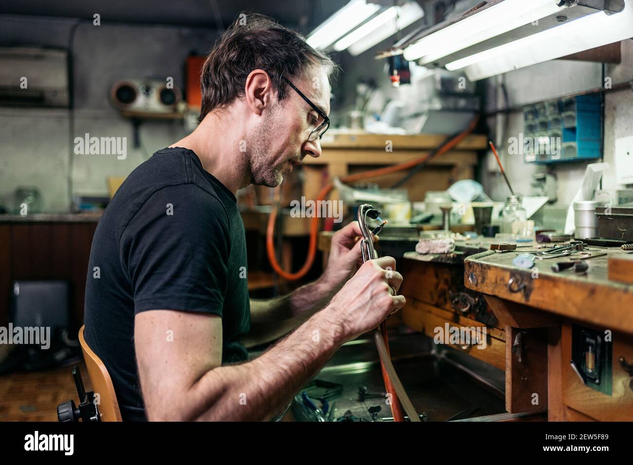 Stock photo of concentrated man working with tools in artisan workshop ...