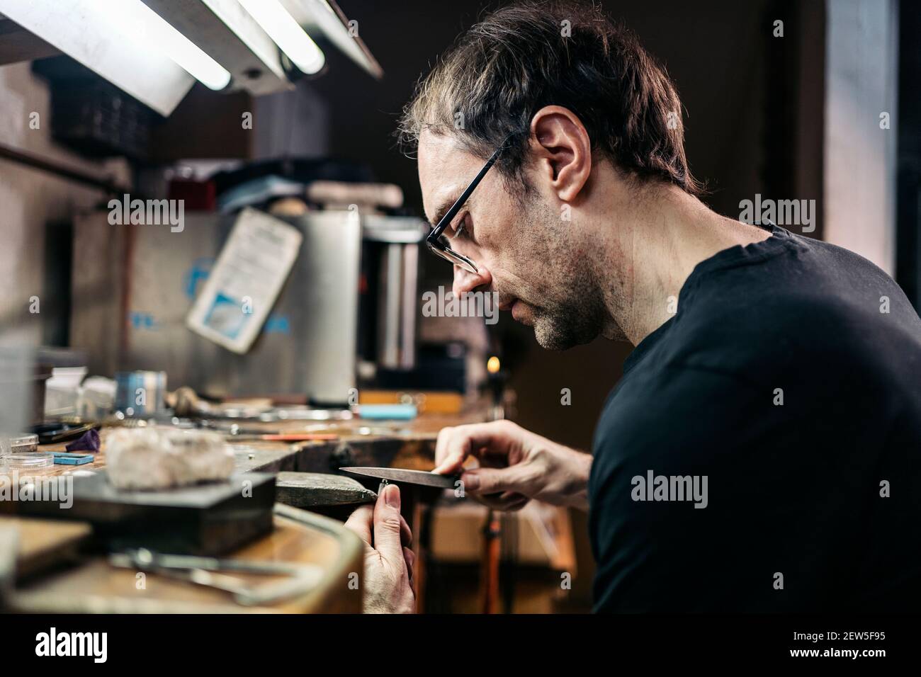 Stock photo of concentrated man working with tools in artisan workshop ...