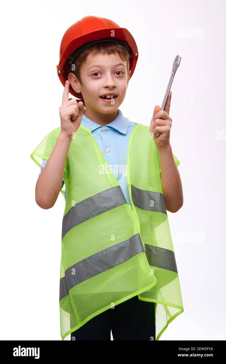 Preschool child construction worker in orange helmet holding wrench on ...