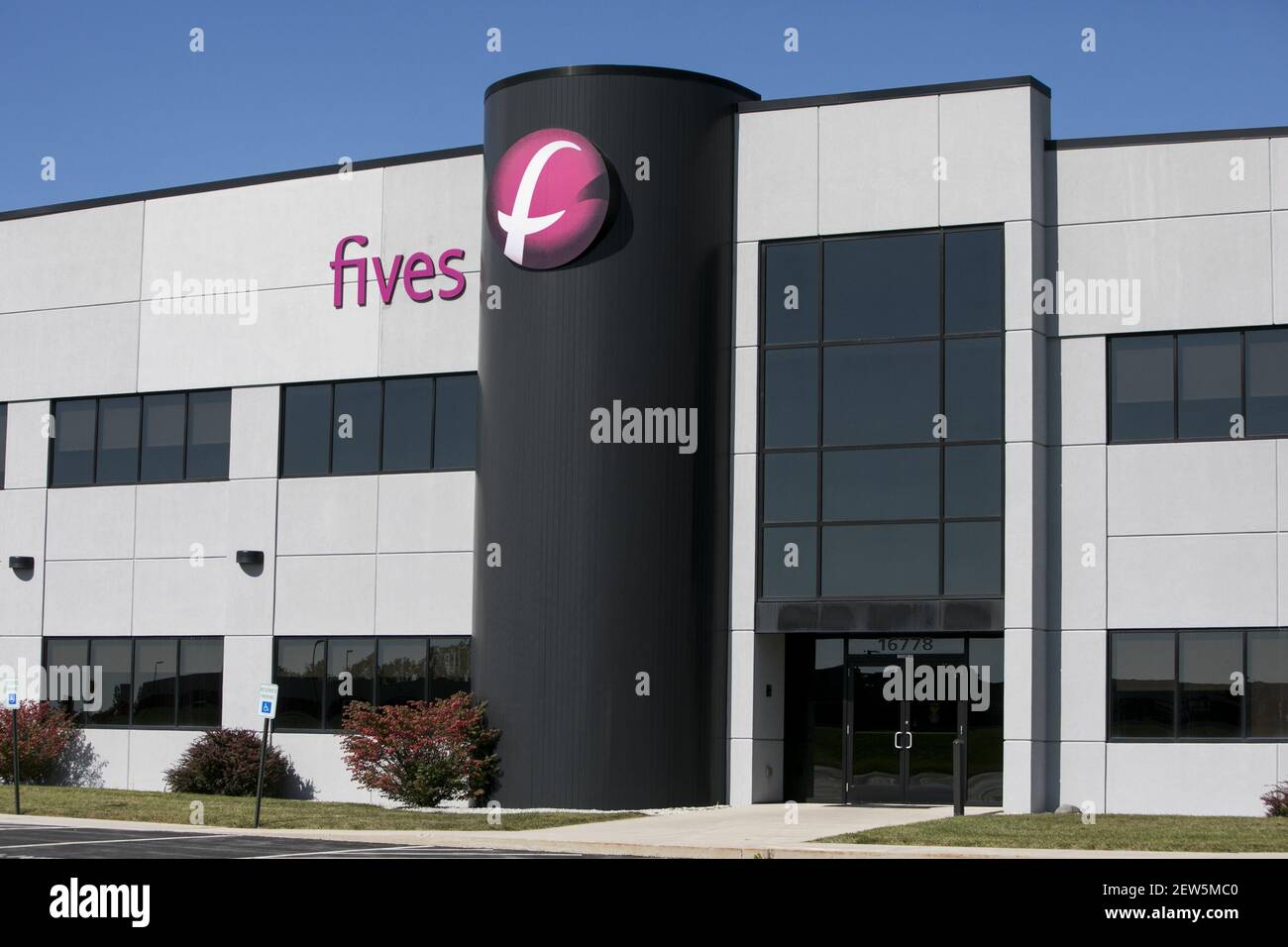 A logo sign outside of a facility occupied by the Fives Group in ...
