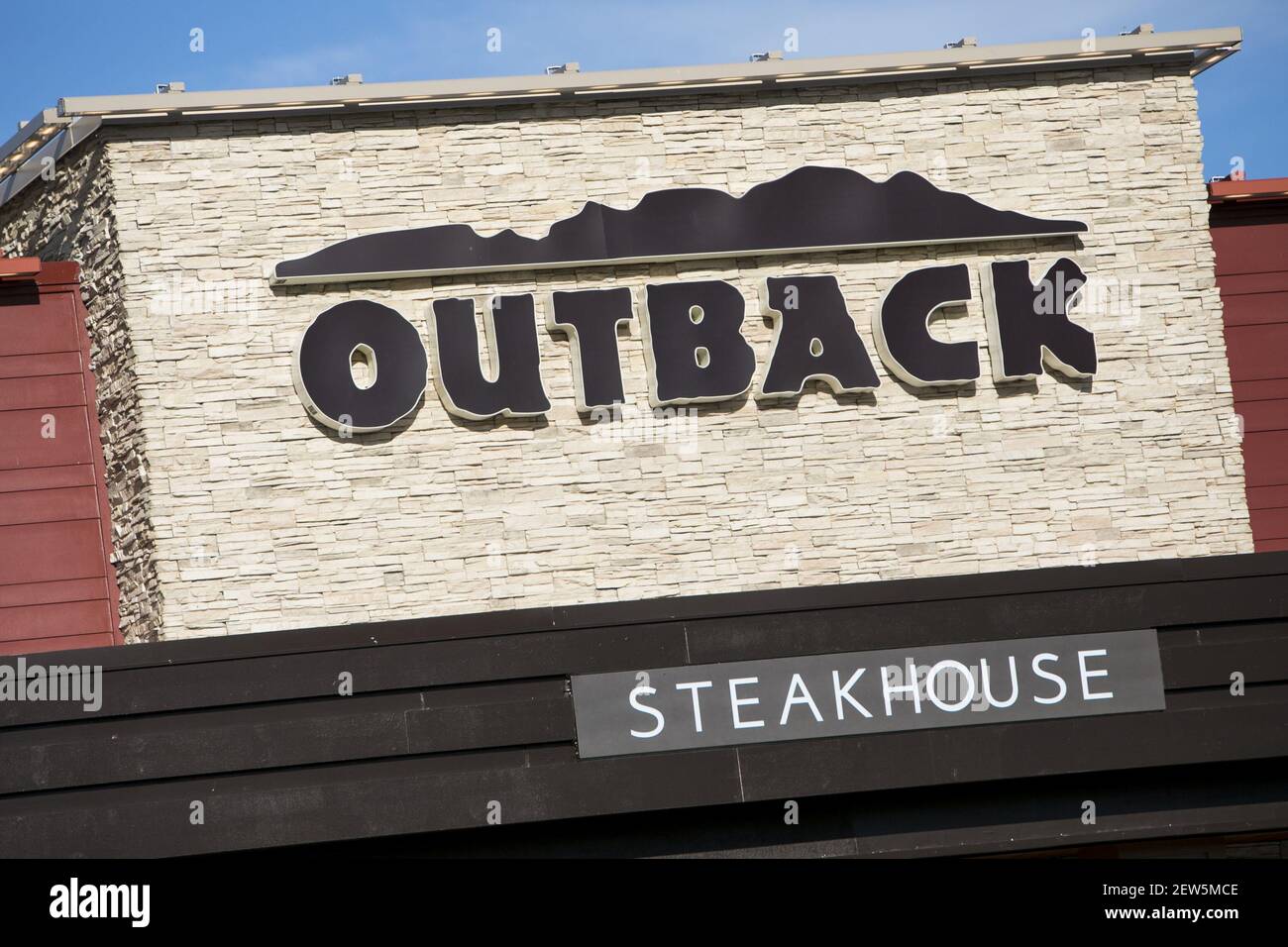 A logo sign outside of a Outback Steakhouse restaurant location in ...