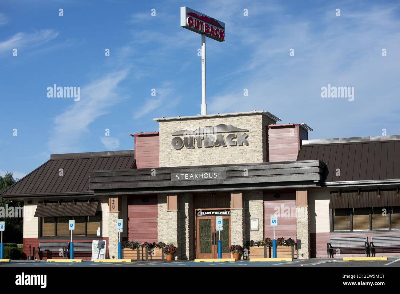 A logo sign outside of a Outback Steakhouse restaurant location in ...