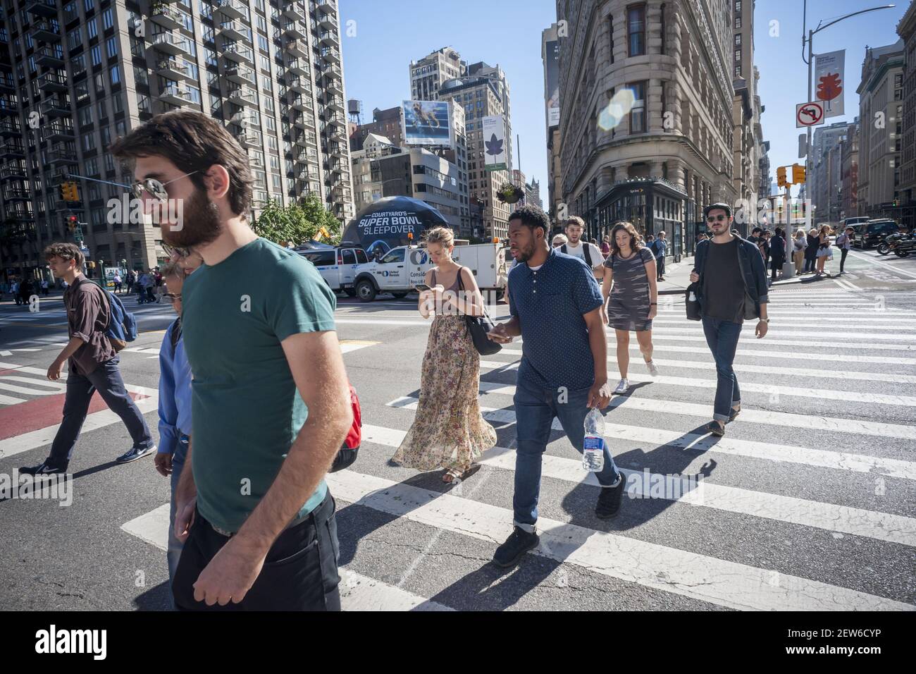 A pedestrian checks her smartphone while crossing an intersection in ...
