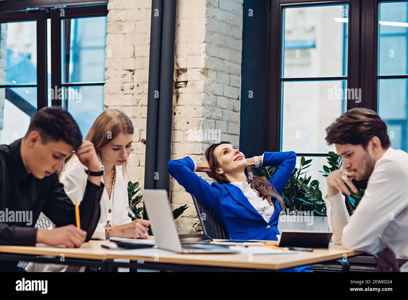 Businesswoman relax while her colleagues working Stock Photo - Alamy