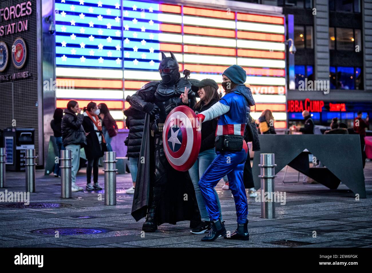 February 28, 2021: A tourist takes a photo with Batman and Captain ...