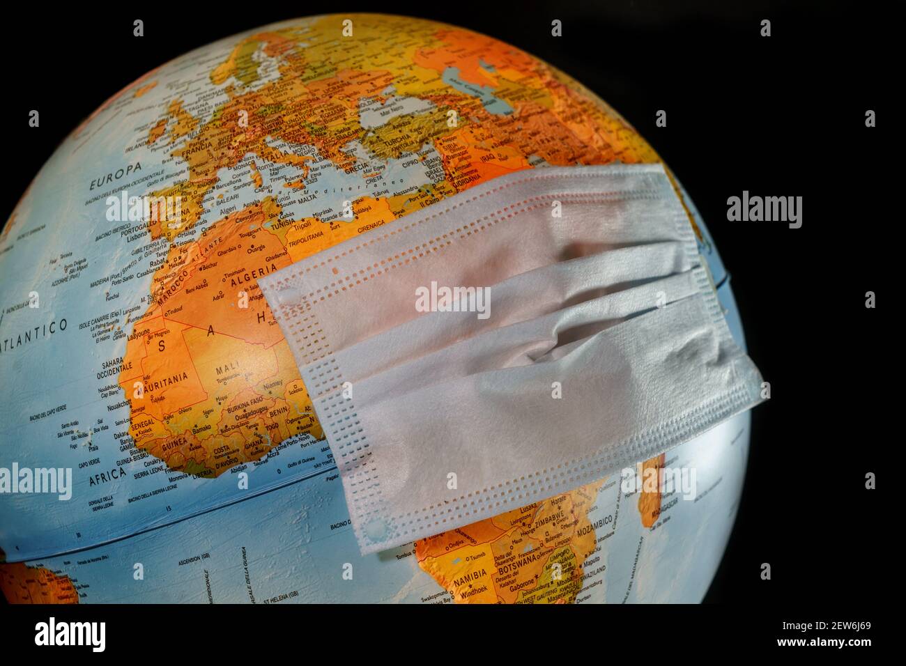 Globe sphere with face mask, world pandemic concept, isolated on black ...