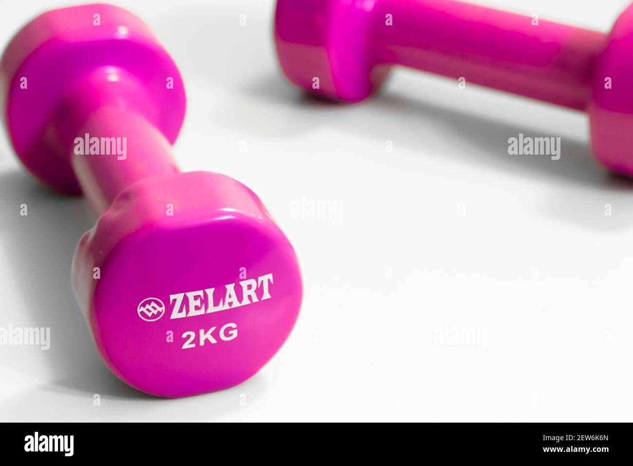 Two styled rubberized pink two-kilogram dumbbells isolated on white ...