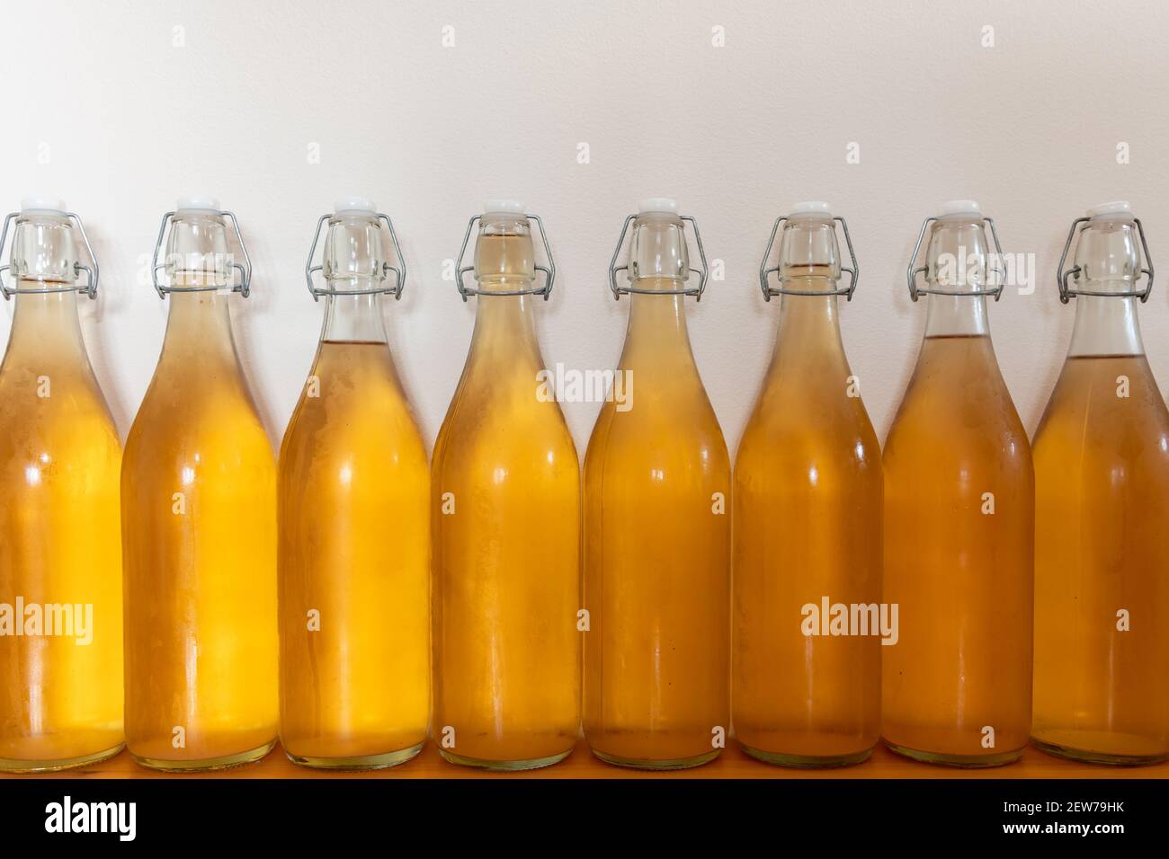 Close up of a row of flip top bottles of home made cider covered in ...