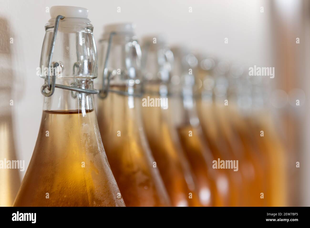 Close up of a row of flip top bottles of home made cider covered in ...