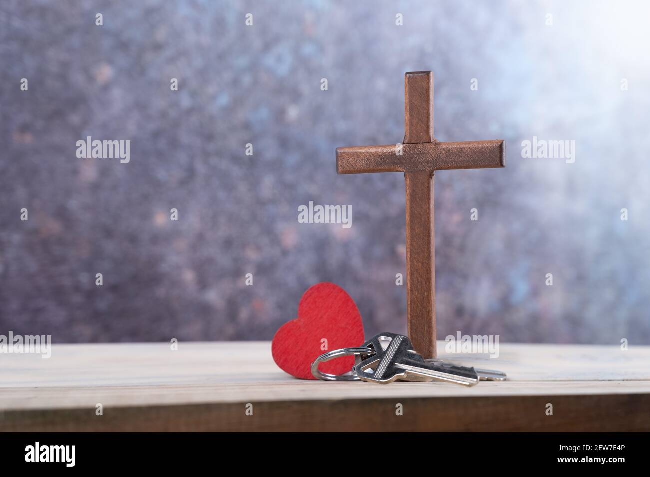 House keys with Wooden cross next to small red Heart on white ...