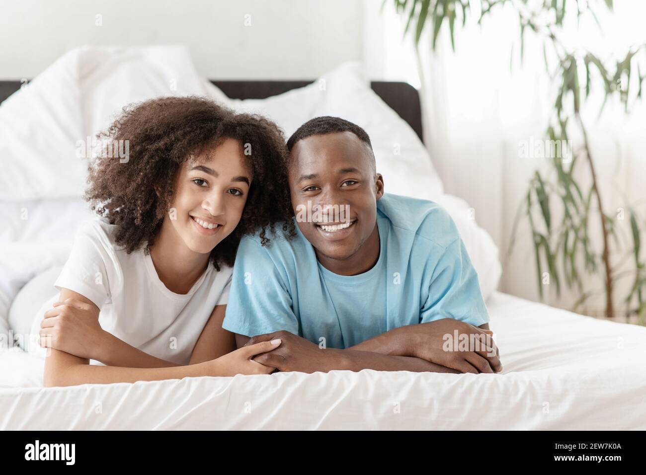 Young cute smiling couple together in bed, popular home bloggers during ...