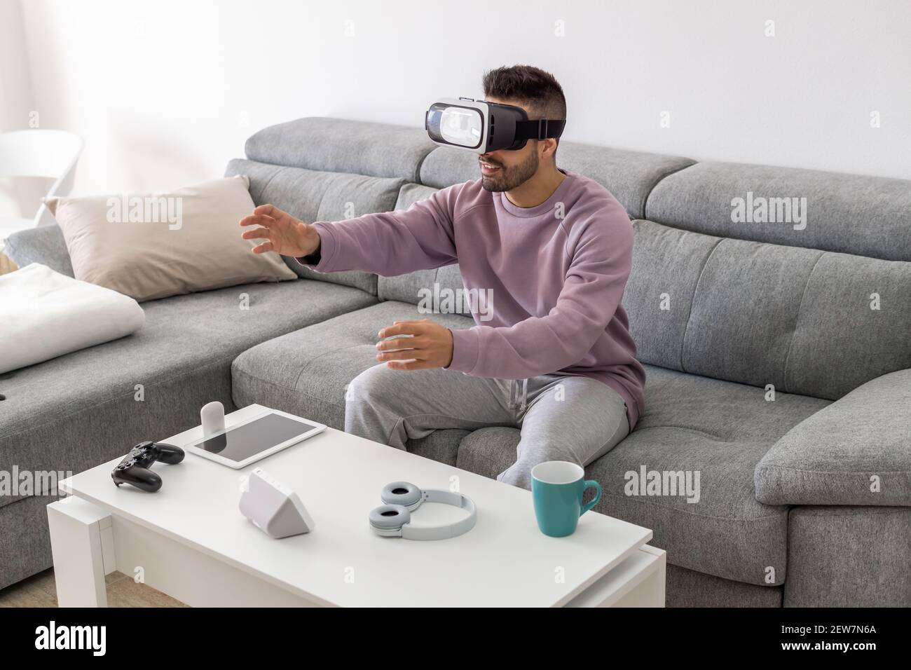 An adult male playing video games with a VR headset while sitting on ...