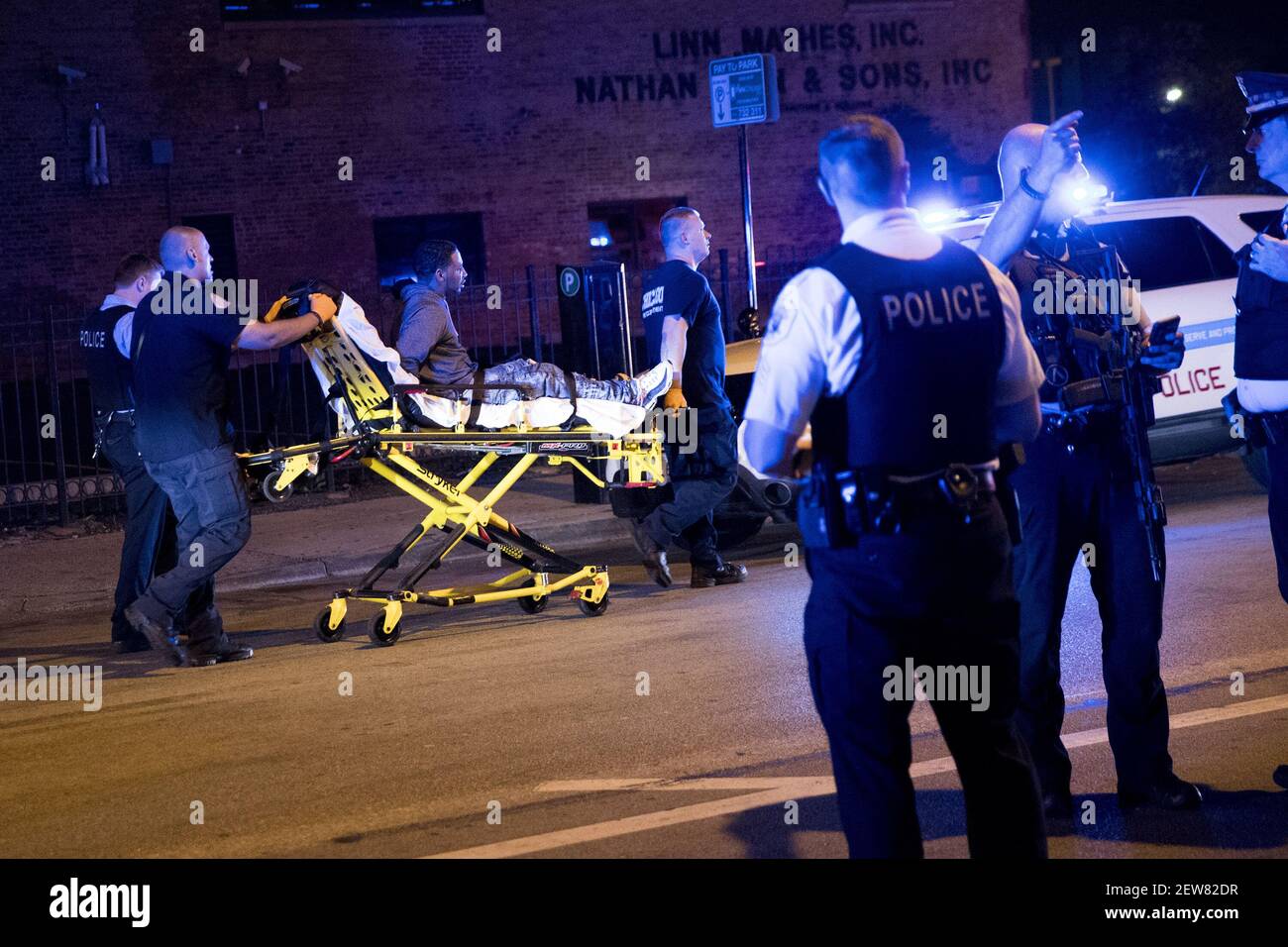 A man is taken away on a stretcher at the scene where three people were ...