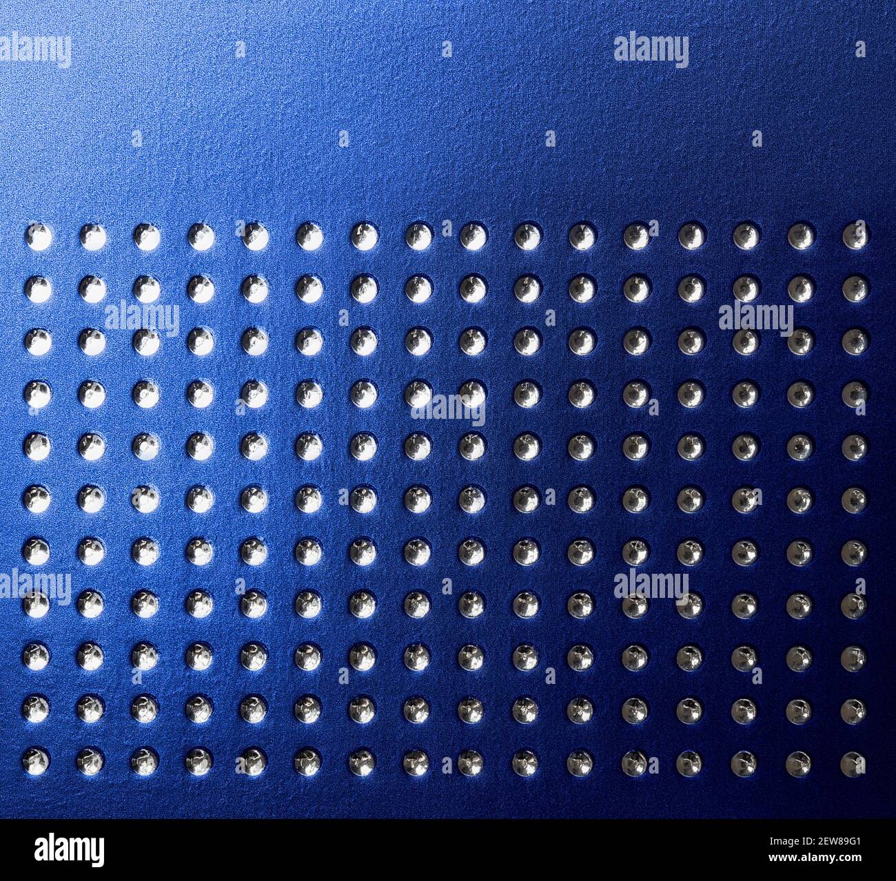 Macro of blue textured paper with concave silver dots pattern ...