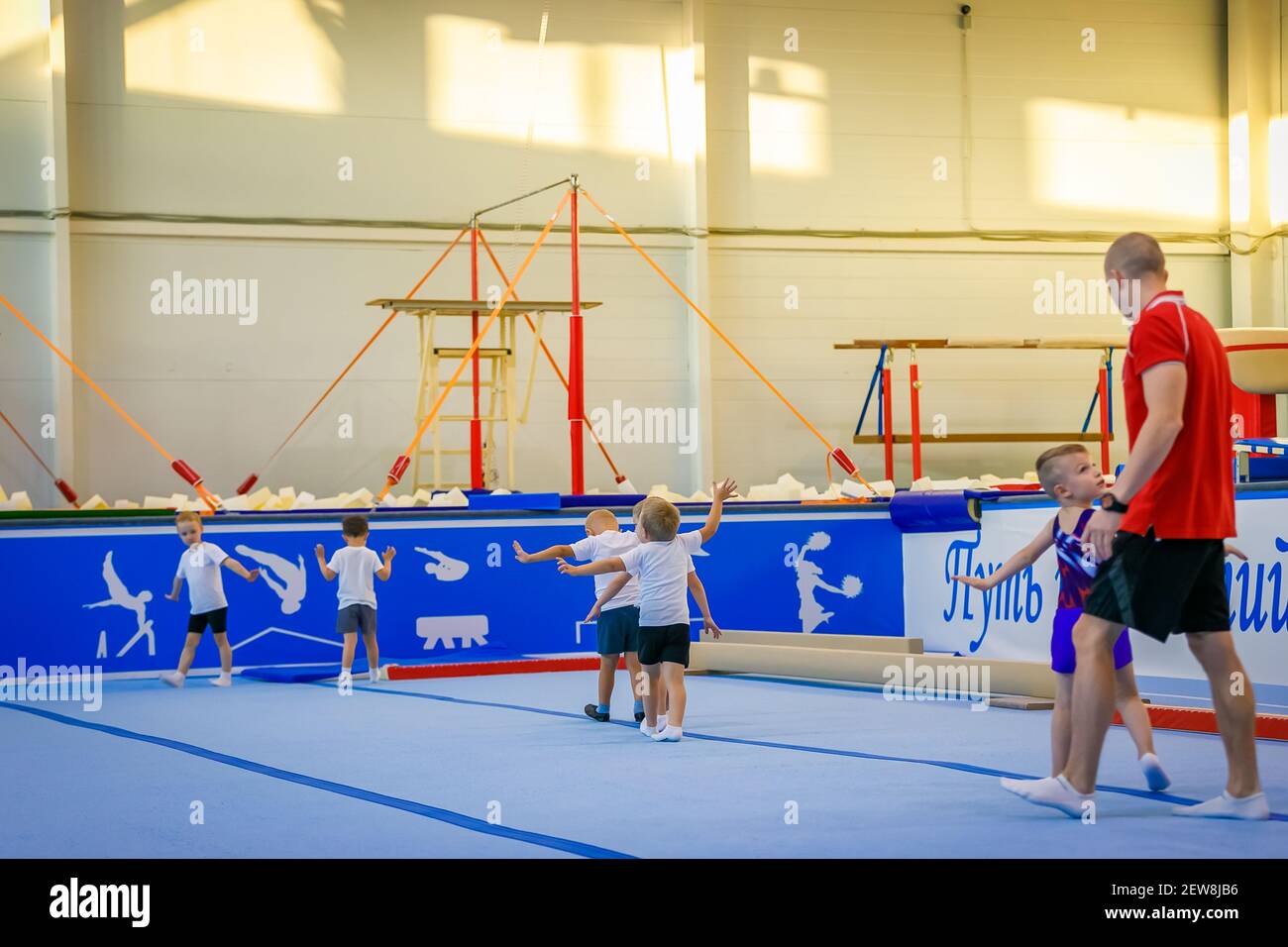 Small children, boys in training run in a circle in the hall under the ...
