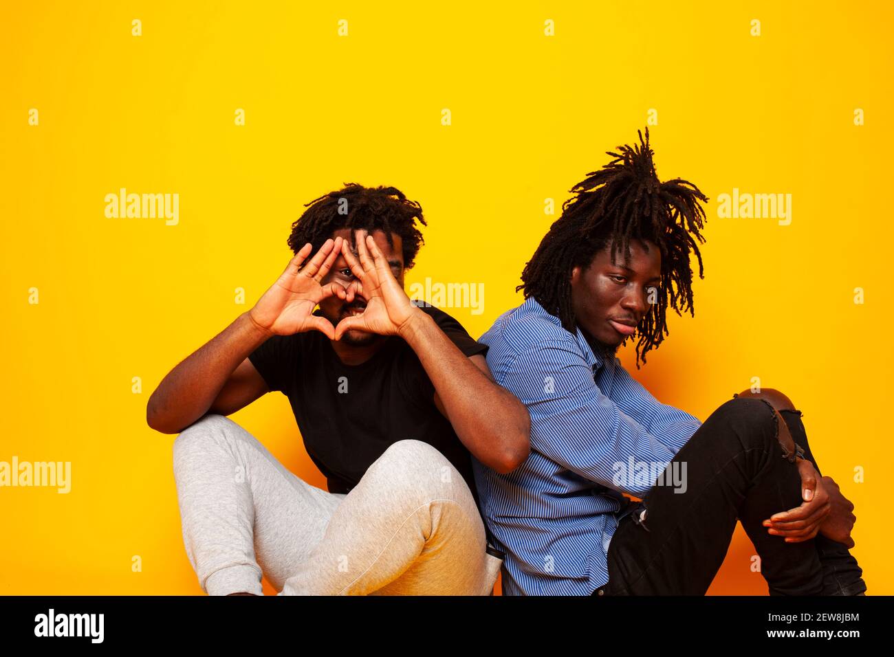 two african american guys posing cheerful together on yellow background ...