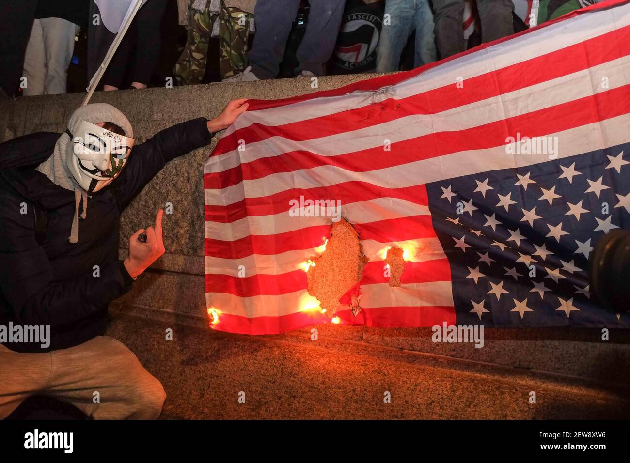 The American flag is burnt in Trafalgar Square. Protesters many of whom ...