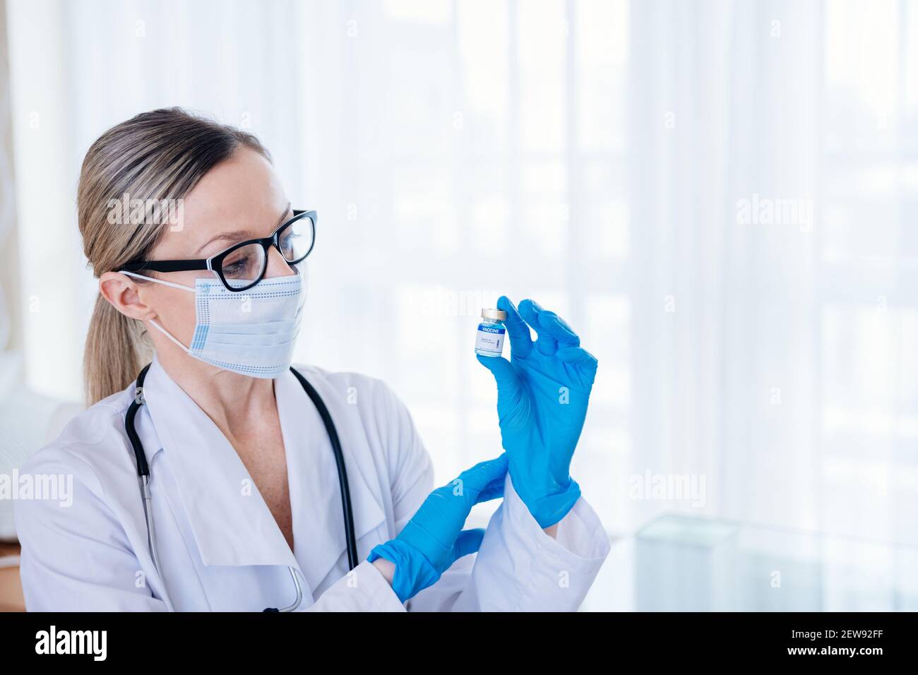 Female doctor in a protective mask and surgical gloves holding an ...