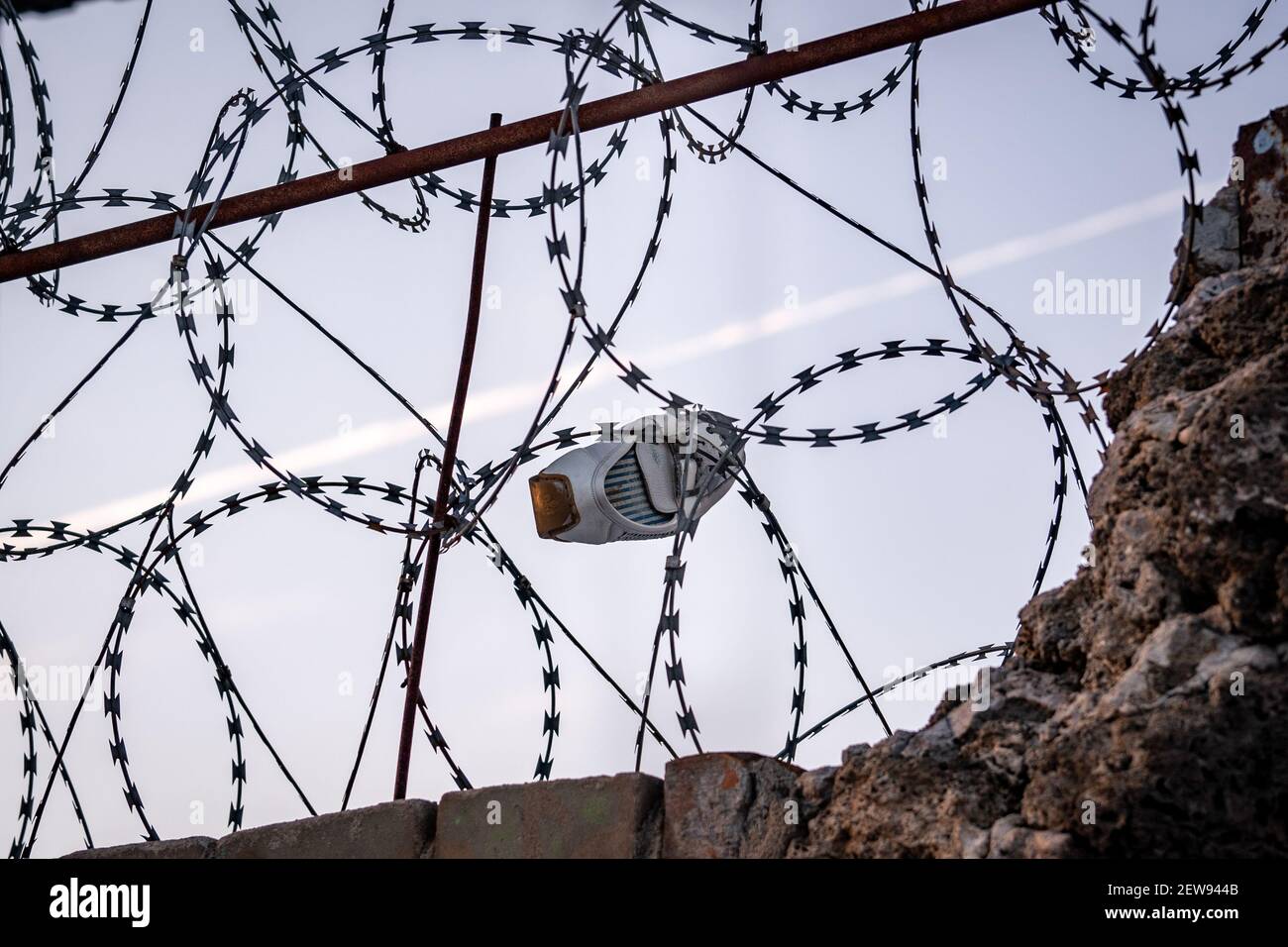 shoe in barbed wire fence Stock Photo - Alamy