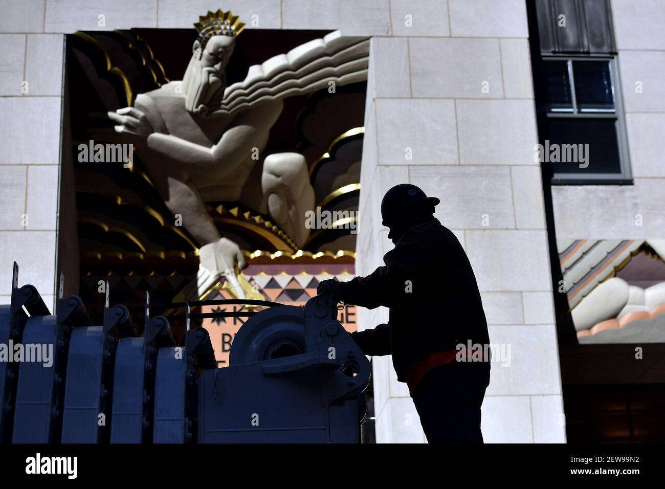 An ironworker helps ready the crane that will hoist the 75-foot Norway ...