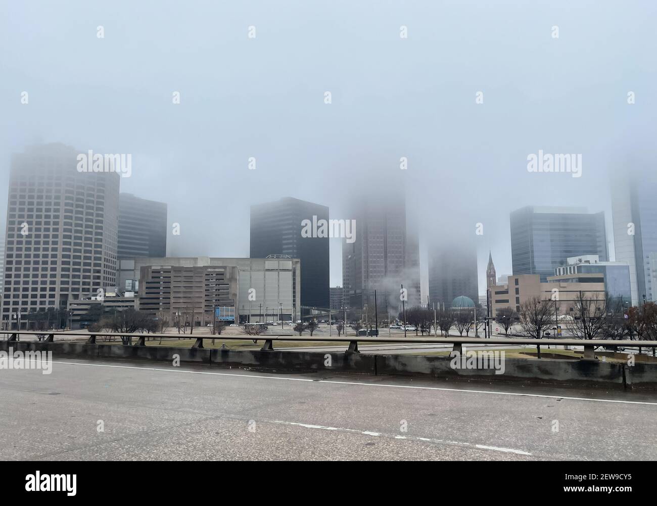 Roadside view of city buildings covered by heavy fog Stock Photo - Alamy
