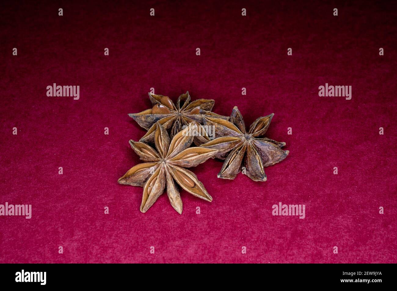 A closeup of dried star anise on a red surface under the lights Stock ...