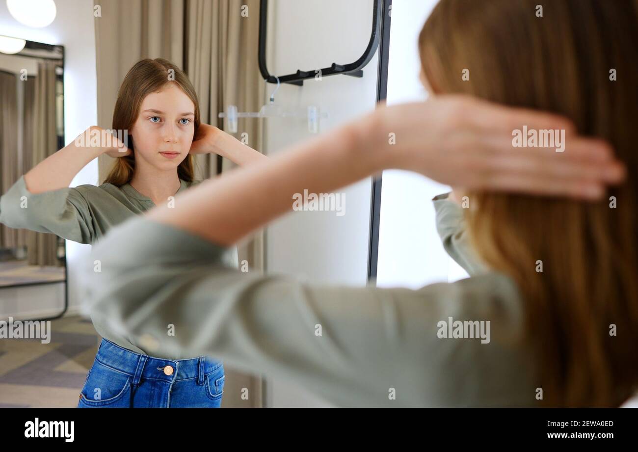 Tween girl standing in fitting room in clothing store Stock Photo - Alamy