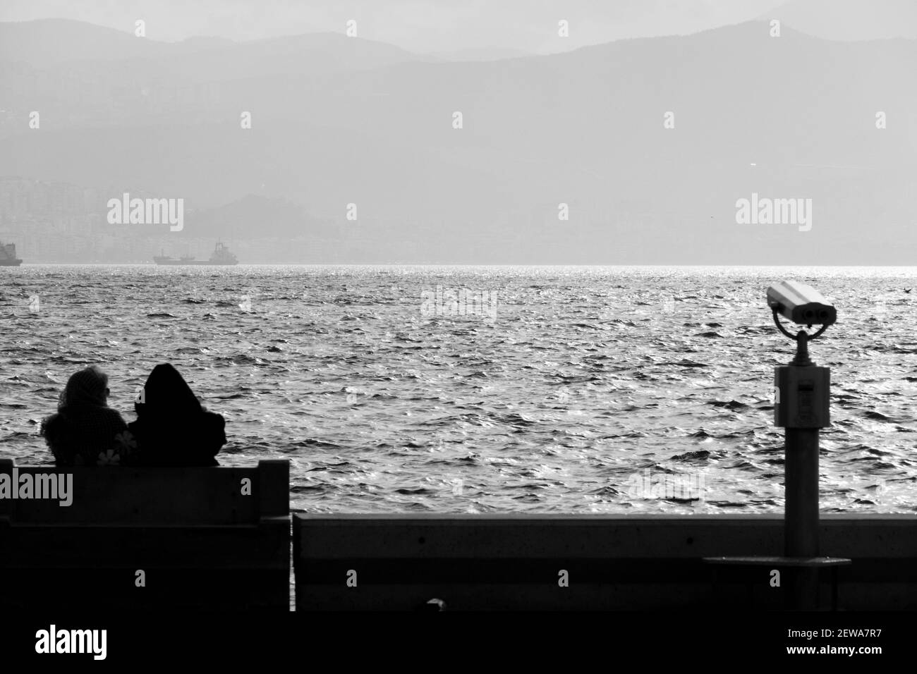 Two people sitting on the bench against the sea view at the seaside and ...