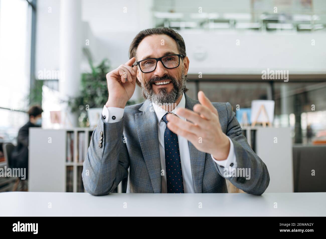 Happy grey-haired male manager on video conference with coworkers ...