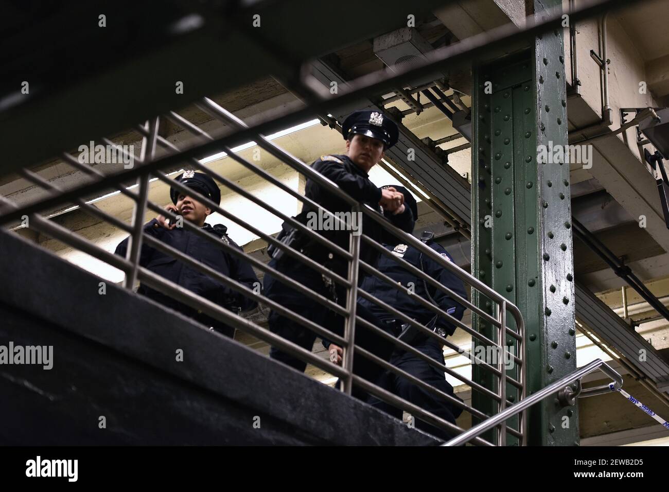 NYPD officers stand at the top of stairs leading to the subway ...