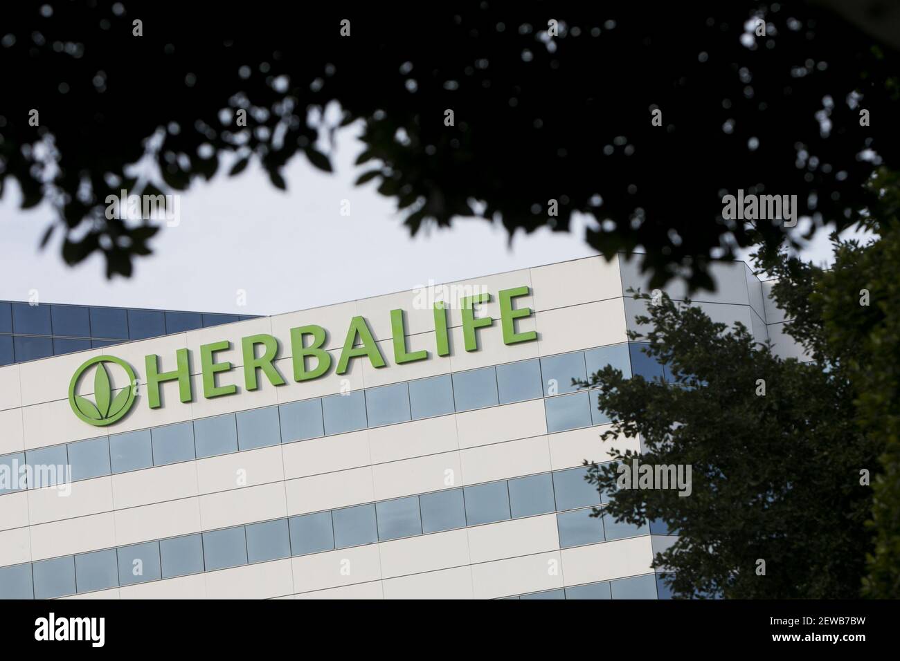 A logo sign outside of a facility occupied by Herbalife International ...