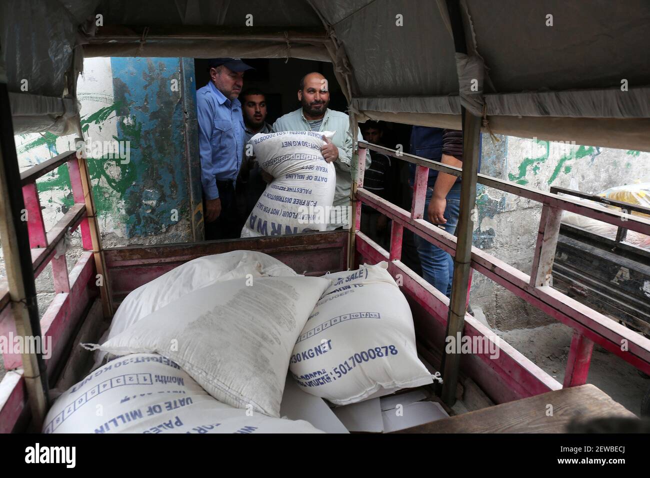 Palestinians receive their monthly food aid at a United Nations ...