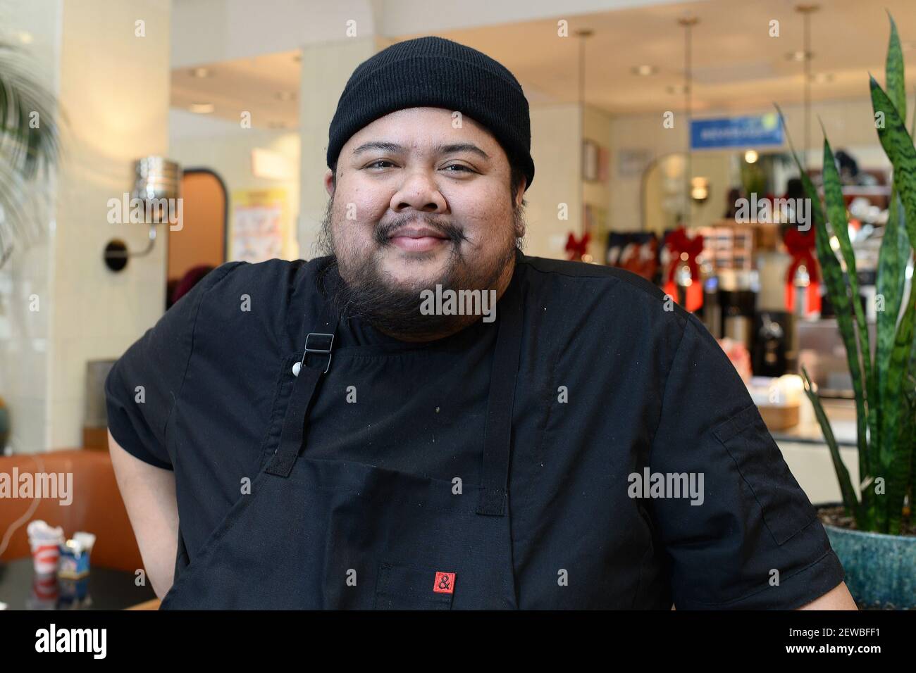 Chef Alvin Cailan's poses with the "Foot Feta-ish" burger, inspired by the animated TV show Bob ...
