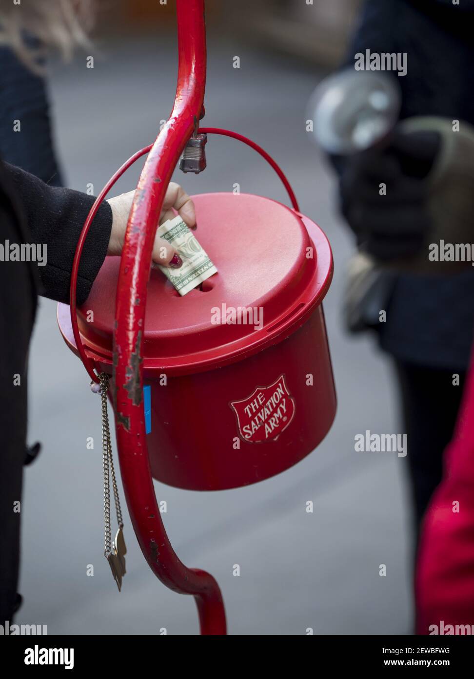 People donate to a Salvation Army collection bucket on December 19 ...