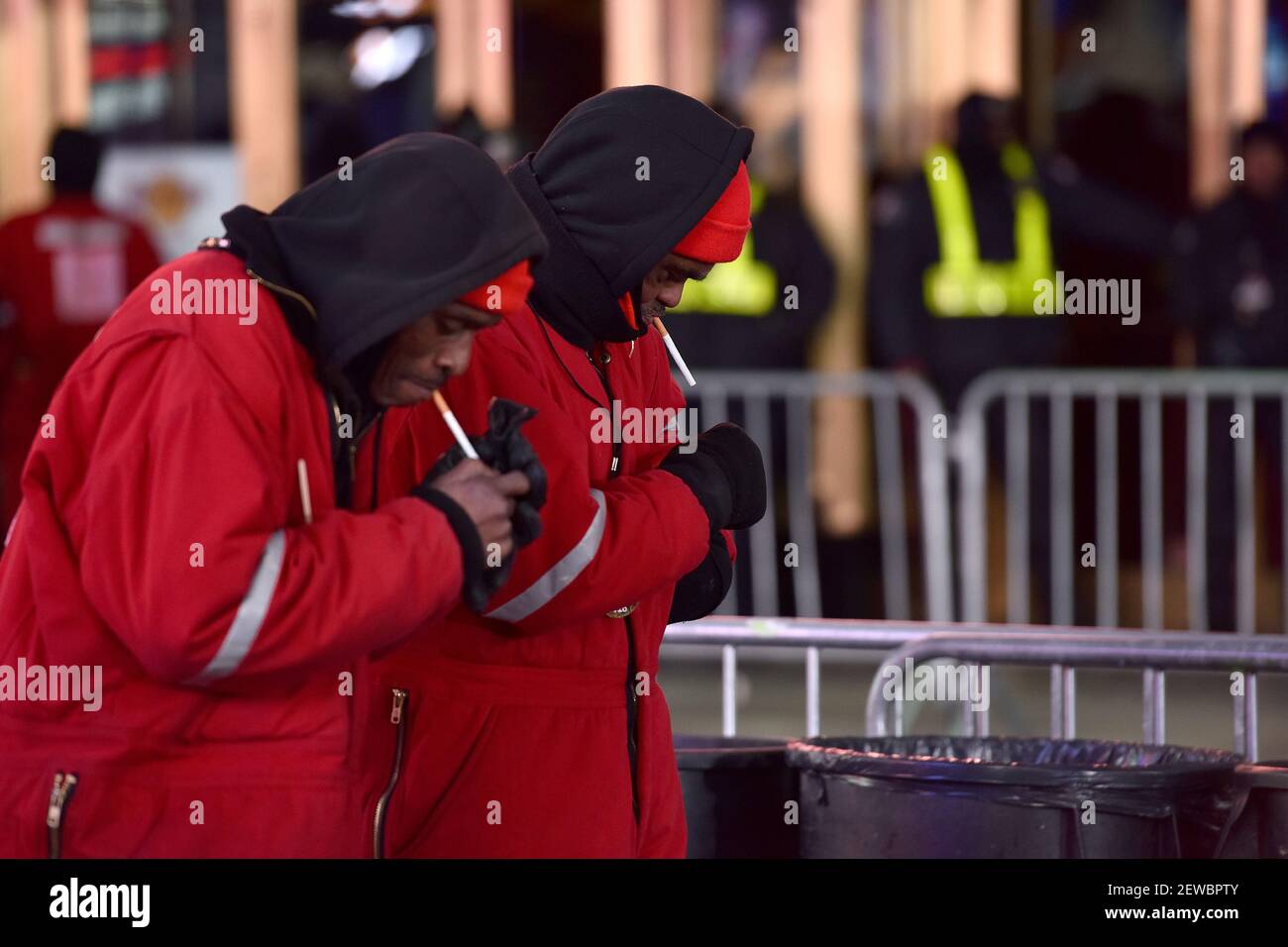 Two Times Square Alliance clean-up crew members light cigarettes as ...