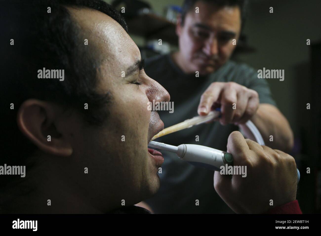 Jose Rodriguez Jr. brushes his teeth while his dad, Jose Rodriguez Sr ...