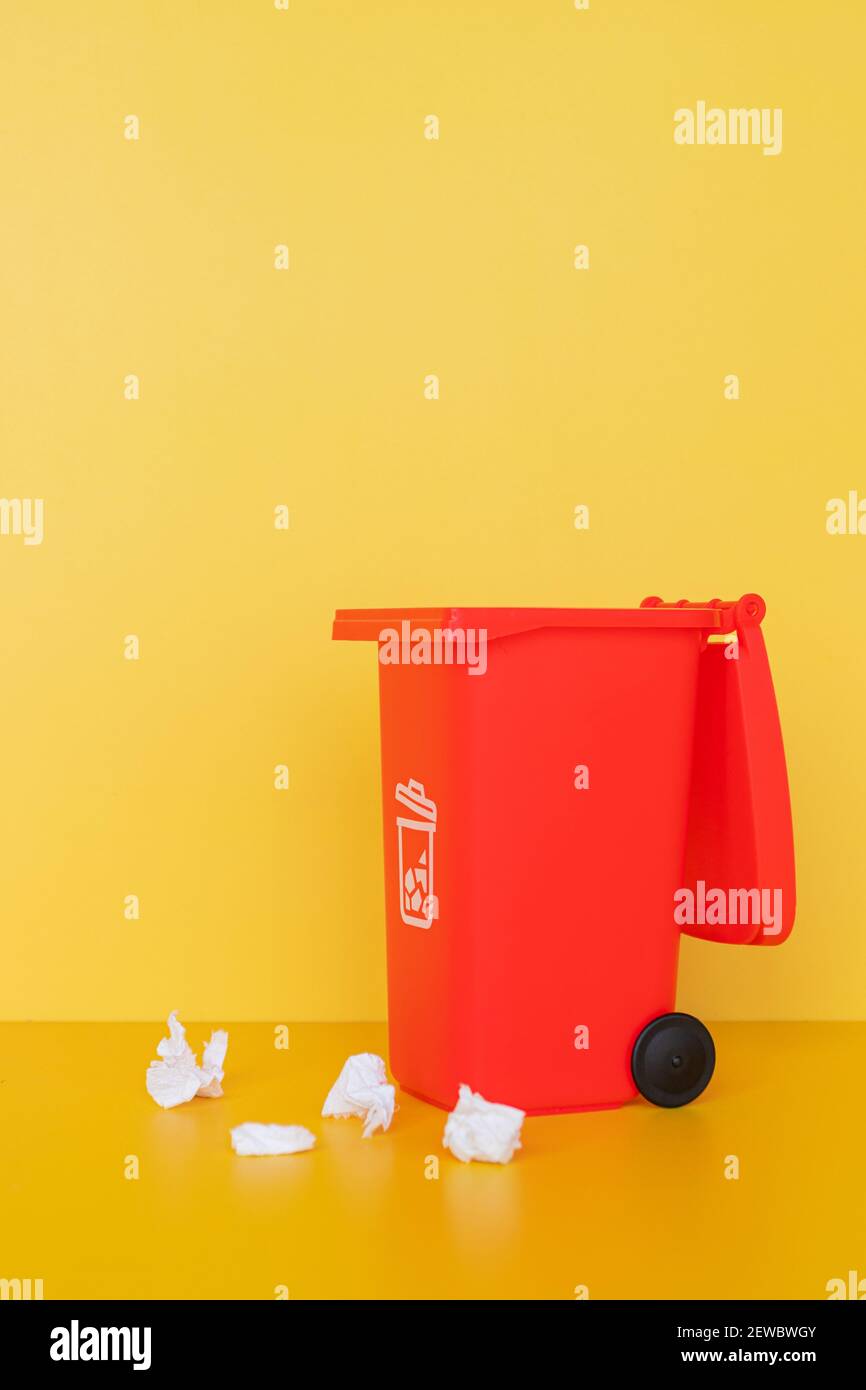 Red garbage container on yellow background Stock Photo - Alamy