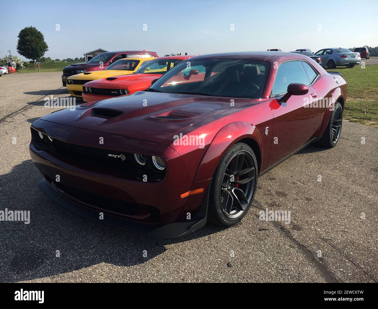 A wide-body Dodge Challenger SRT Hellcat sits with other Hellcat and ...