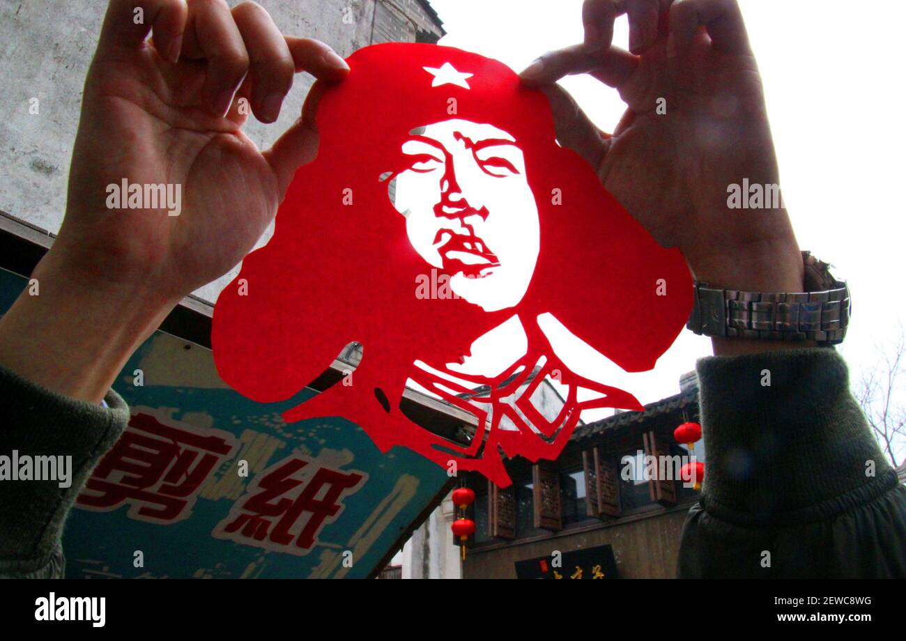 --FILE--A street artist shows his paper cutting of Lei Feng on Lei Feng ...