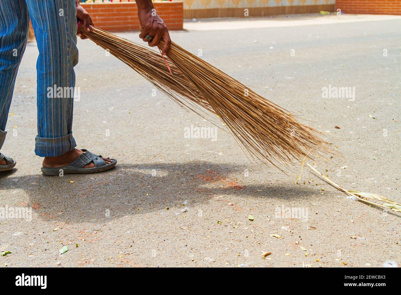 A man with a hand broom sweeping the street Stock Photo - Alamy