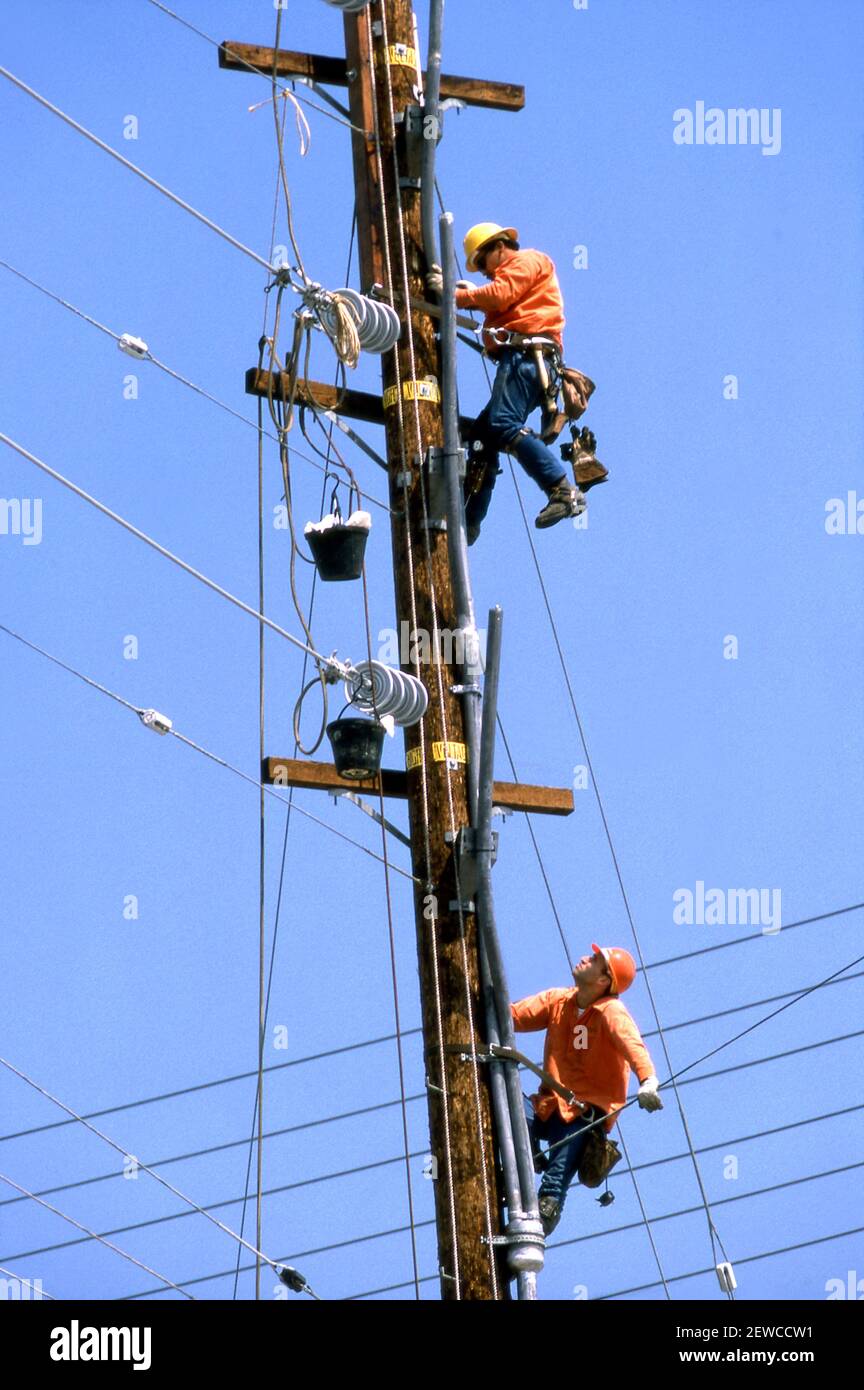 Men in hardhats working on electrical lines Stock Photo - Alamy
