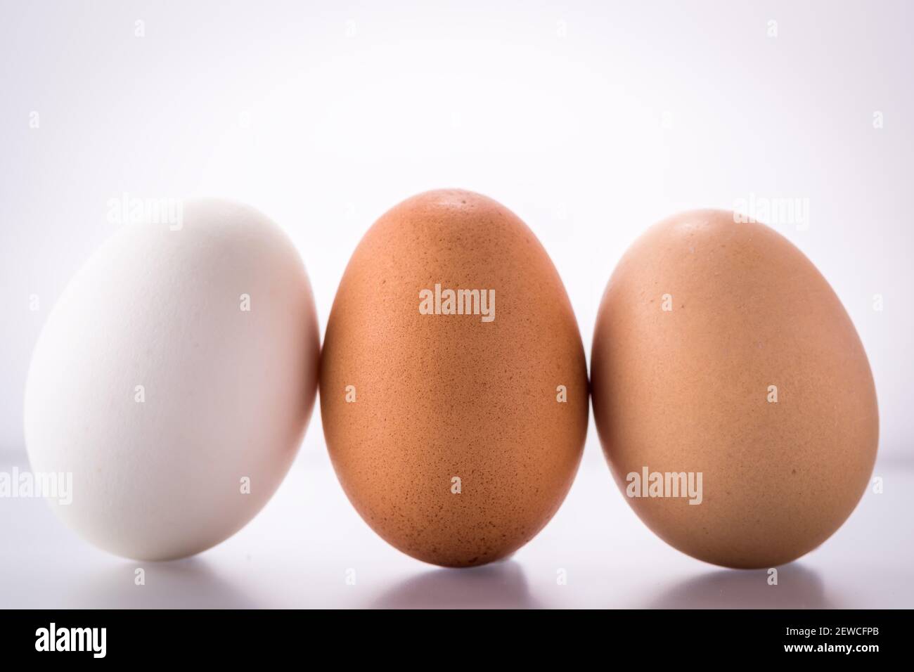 Three (3) different shades of natural organic eggs on a white ...
