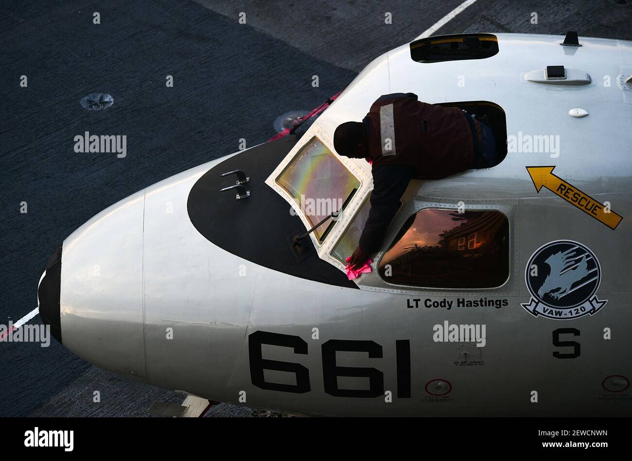 A Sailor performs a pre-flight check on an E2-C Hawkeye assigned to the ...